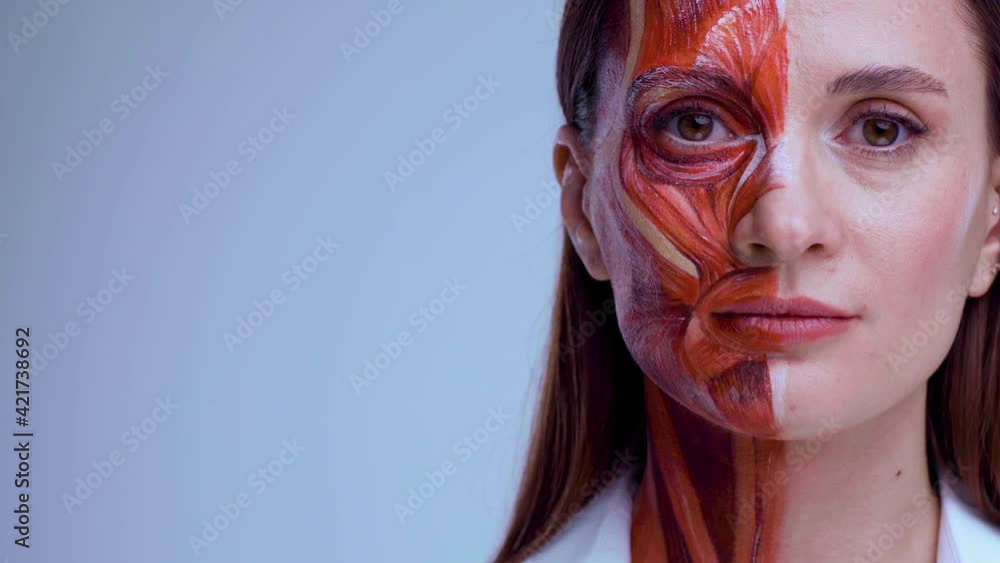 Young woman with half of face with muscles structure under skin. Model ...