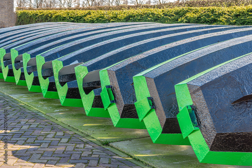 Recently painted and tarred motor boats drying in a row in the sun. The ...