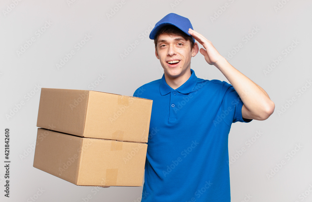 young package deliver boy looking happy, astonished and surprised ...