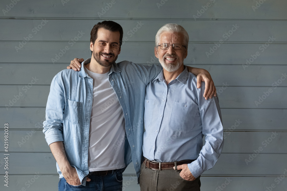 Portrait of smiling old Caucasian 60s father and adult millennial son ...