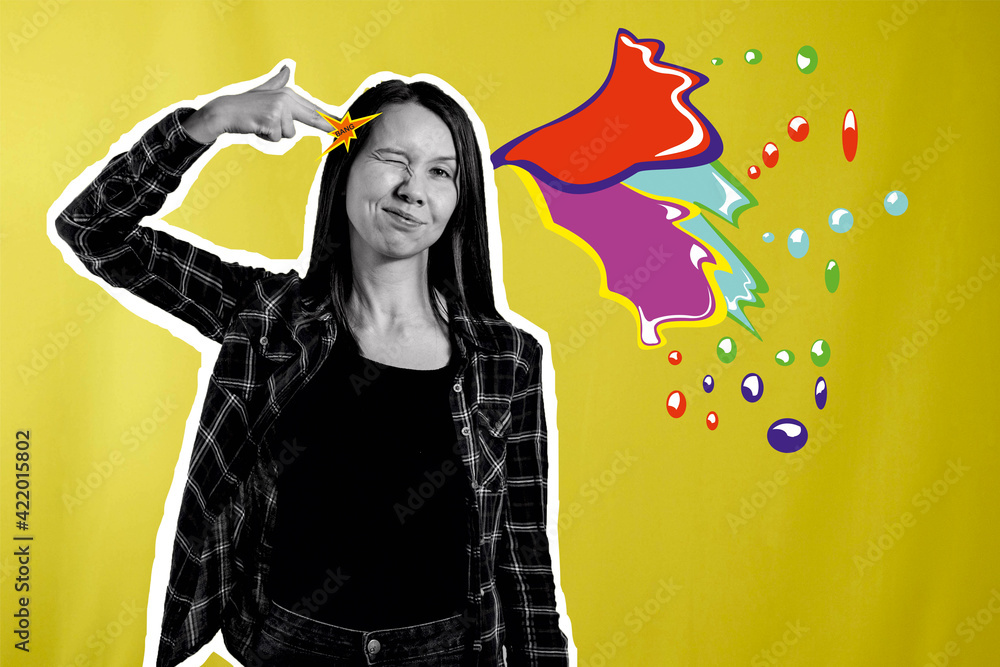 Portrait of a girl who shows a gun gesture to her head with her fingers ...