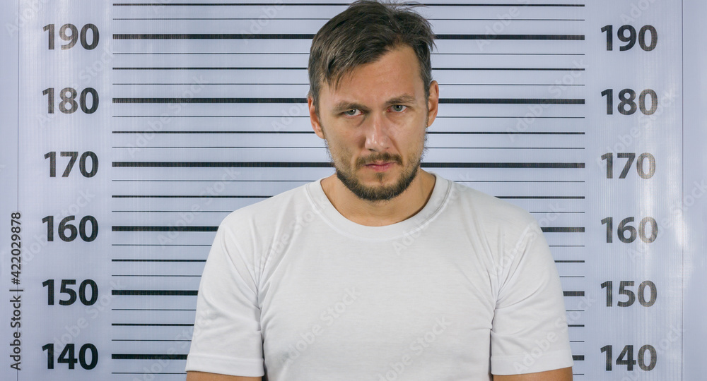 Handcuffed criminal on mugshot takes picture. Mugshot. Stock Photo ...