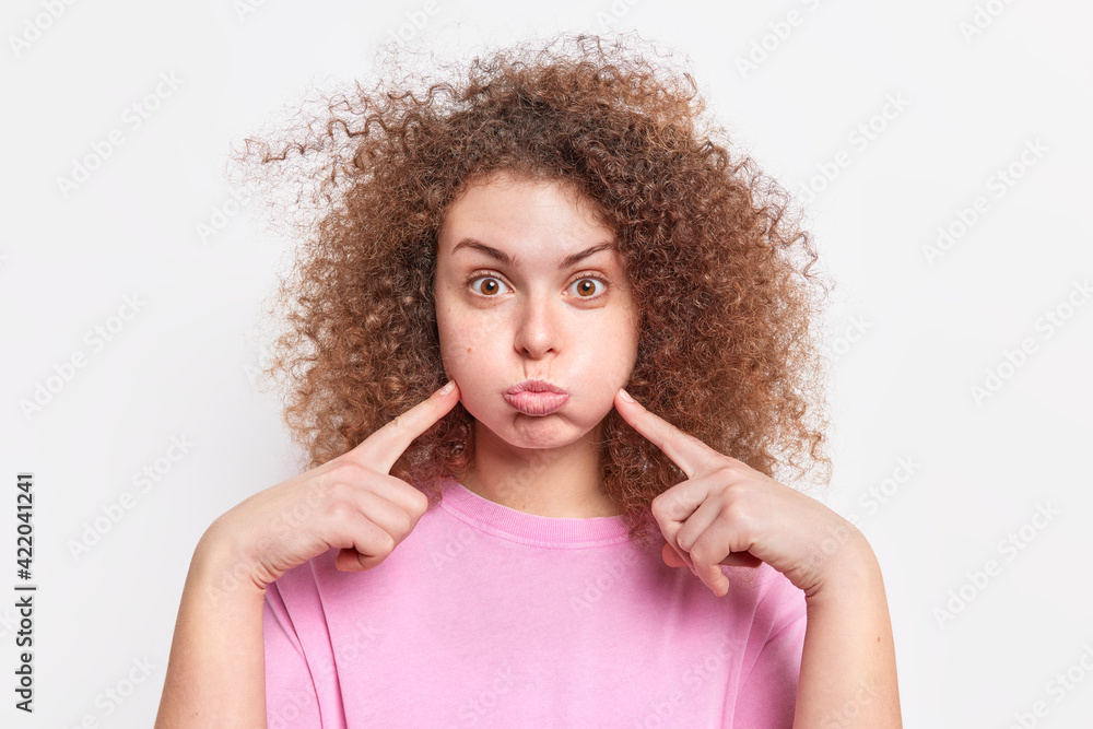 Funny Curly Haired European Woman Blows Cheeks Has Fun Never Looses
