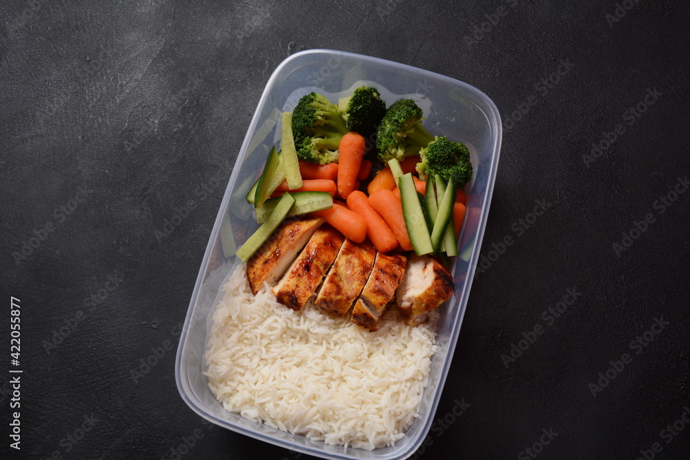 Healthy balanced lunch boxes. Grilled chicken, carrots, cucumbers ...