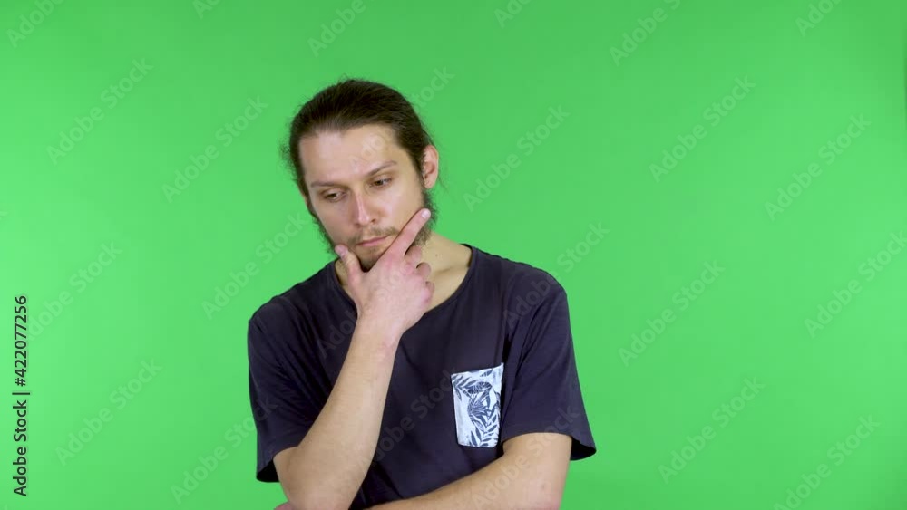 Portrait of a young man looking at the camera, thinking with ...