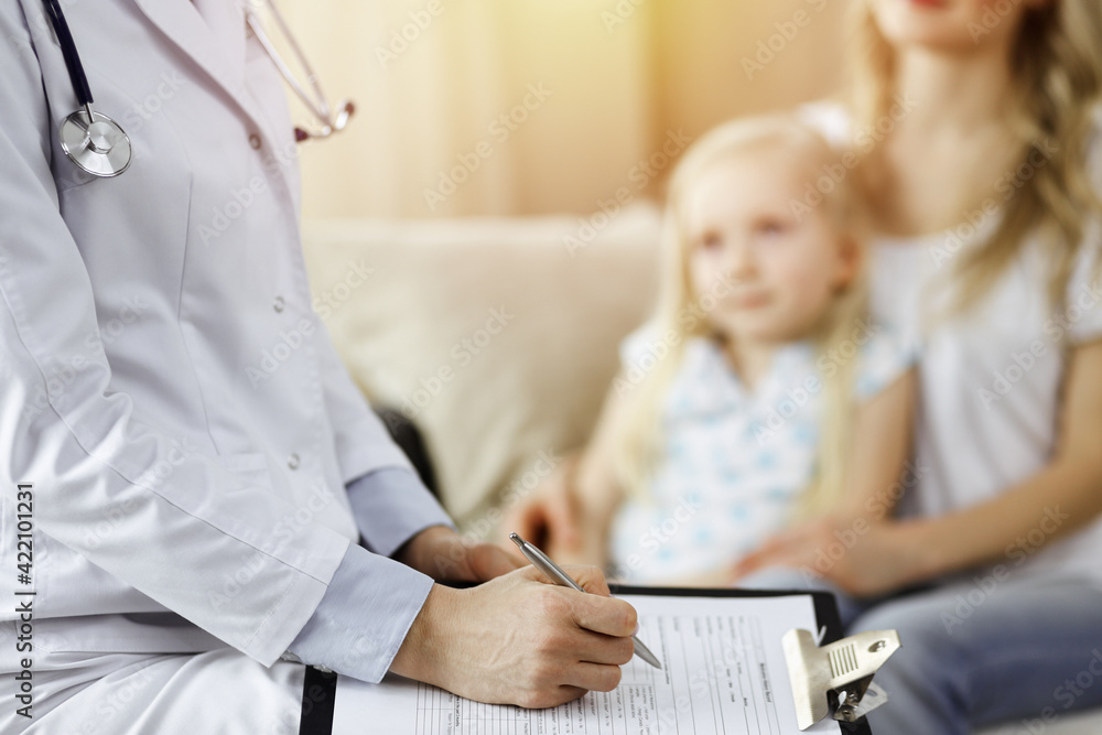 Doctor and patient. Pediatrician using clipboard while examining little ...