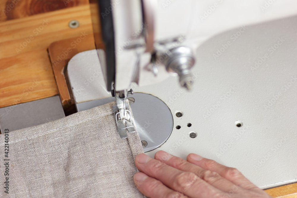 Middle aged woman hands sewing linen cloth on stitching machine, from ...