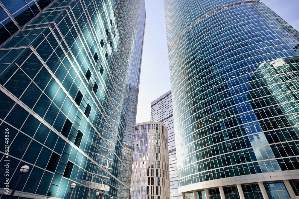 Office and residential skyscrapers against bright sun and clear blue ...