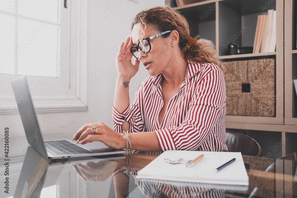 Unhealthy stressed businesswoman taking off eyeglasses, rubbing eyelids ...