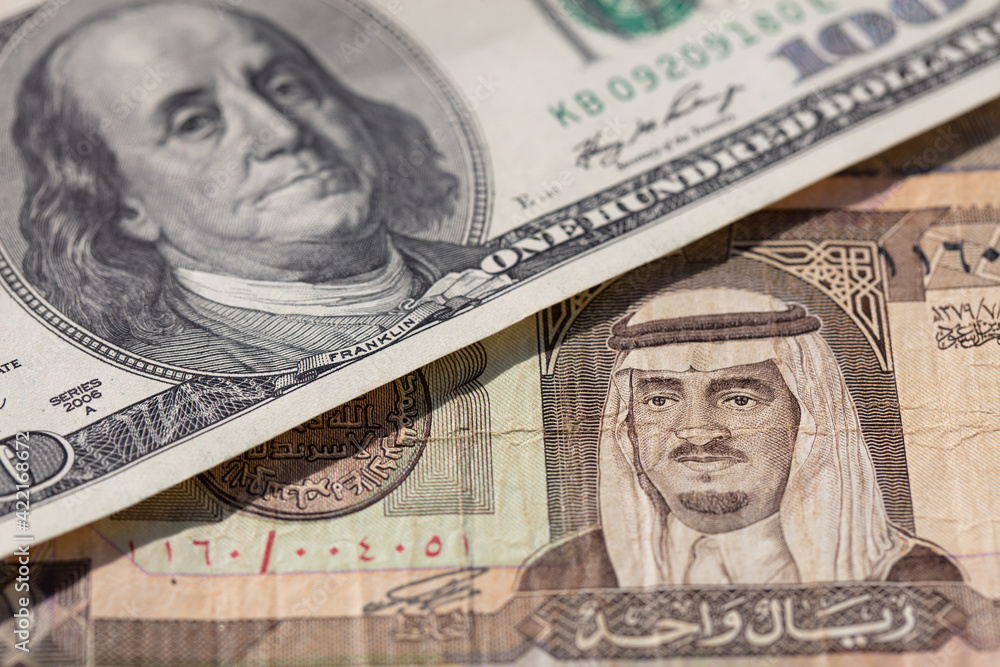 old one riyal of Saudi Arabia and 100 US dollar banknotes Stock Photo ...