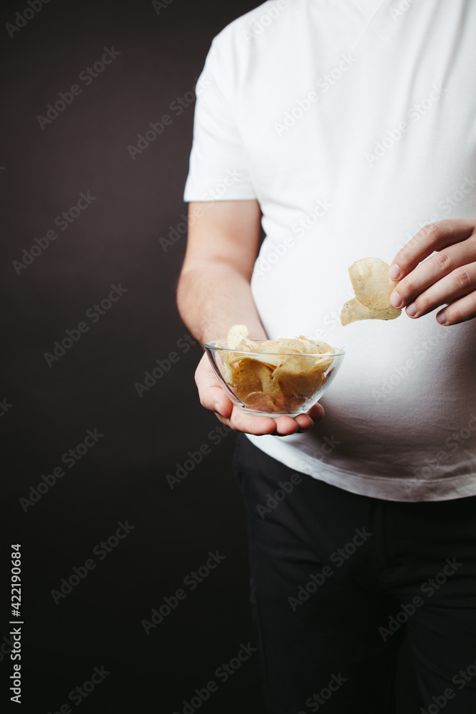 Fat man snacking with potato chips. Junk food Stock Photo | Adobe Stock