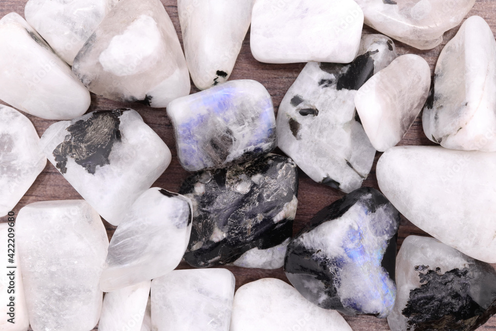 Moon stone heap jewel on brown varnished wood texture. Pile mineral ...