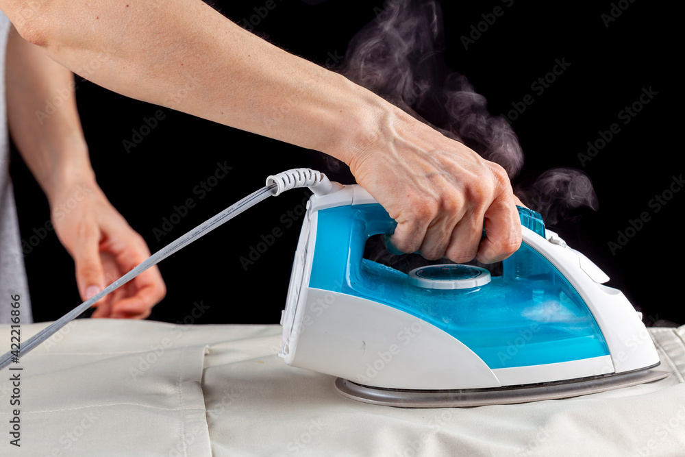 Close up isolated image of a white woman ironing a cloth on an ironing ...