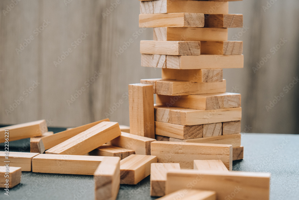 Building from wooden blocks. Game for family of wooden bars. Wood blocks stack game with Hand on ...