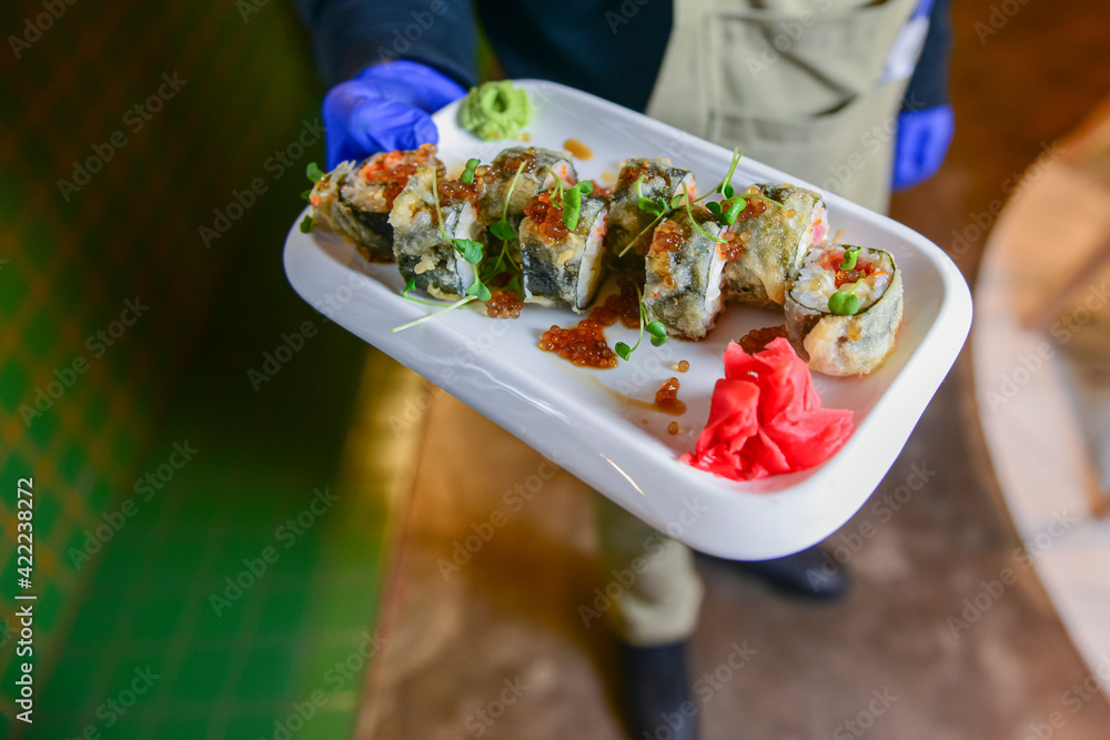 Waiters carrying plates with sushi, restaurant service. Eating out ...