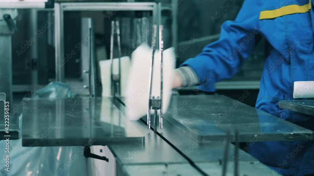 Factory workers placing stacks of white facial tissues on a conveyor ...