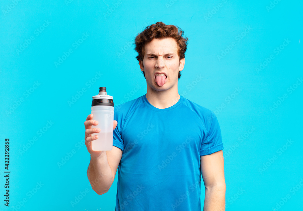 sport boy feeling disgusted and irritated, sticking tongue out ...