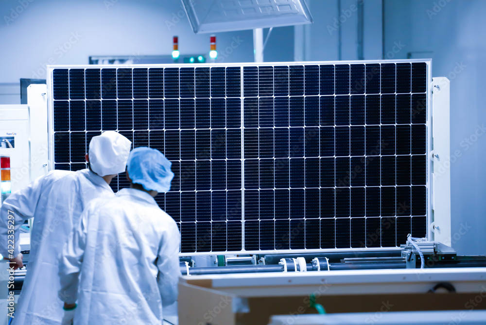 Factory workers lifting new solar panel from production line,and the ...