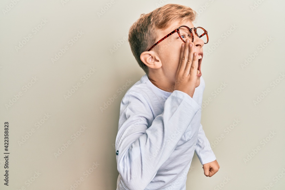 Little caucasian boy kid wearing casual clothes and glasses shouting ...