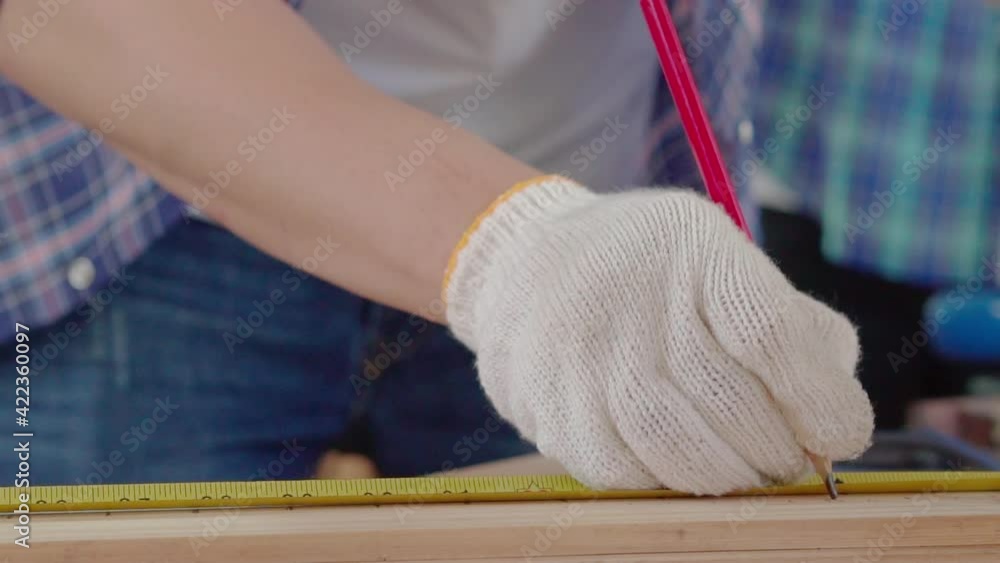 The carpenter is measuring and drawing. Carpenter using a red pencil to ...