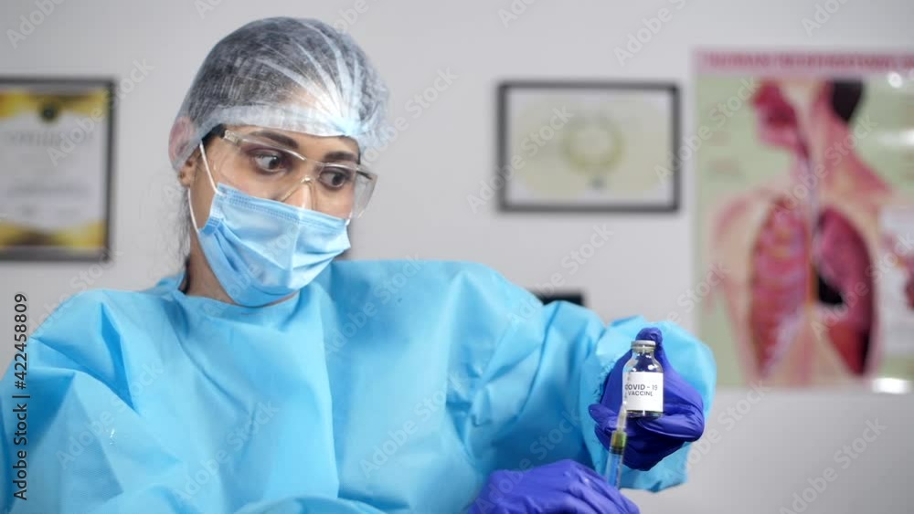 Doctor holding a syringe with injection dose and Coronavirus vaccine ...