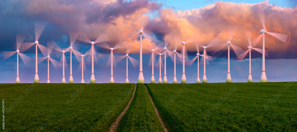 wind turbines in the field during an evening storm with strong winds ...