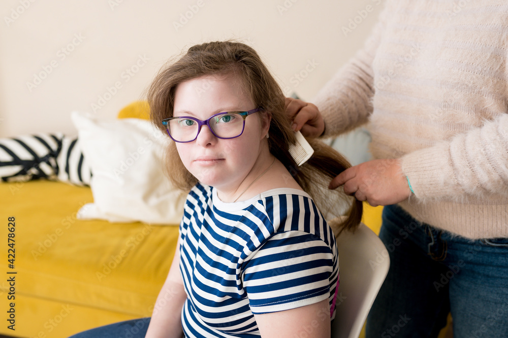 Close-up of mother s hand tying the kid hair in ponytail at home. Mom ...