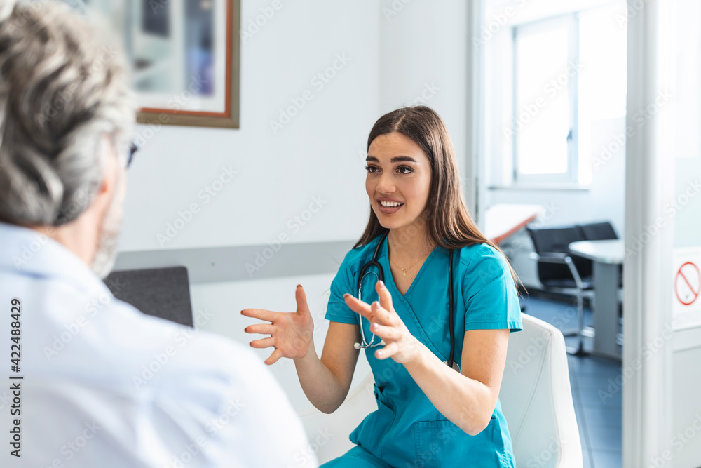 Patient with doctor in hospital waiting room discussing his symptoms ...