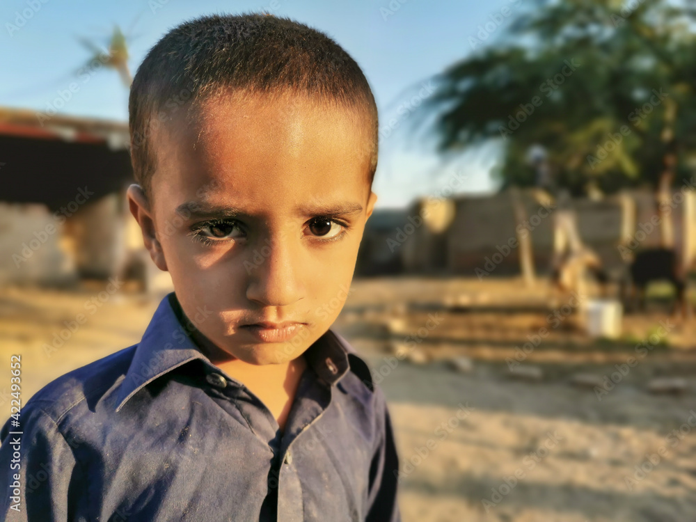 closeup of a poor staring hungry orphan boy in a refugee camp with sad ...