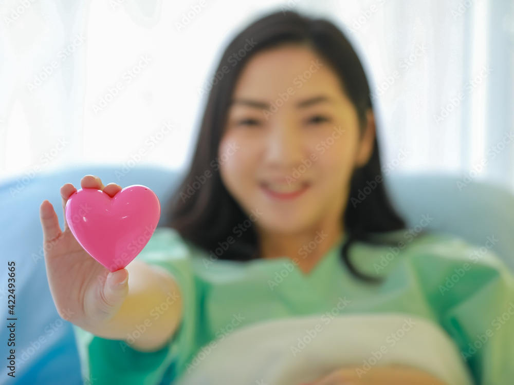 Blur photo of female patient laying on bed in hospital holding and ...