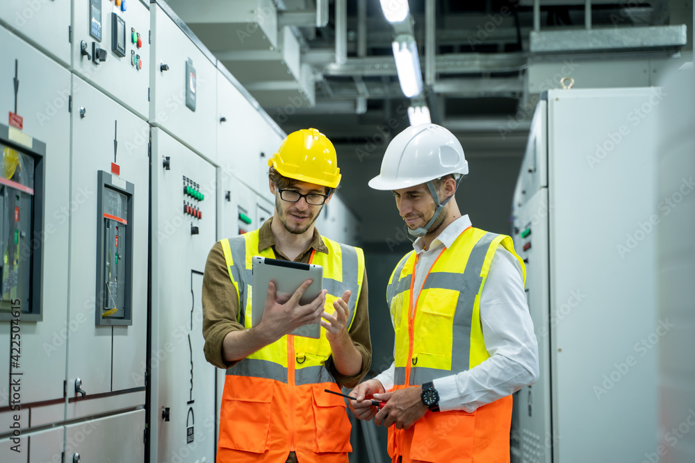 Technical worker with engineer working and checking in control room ...