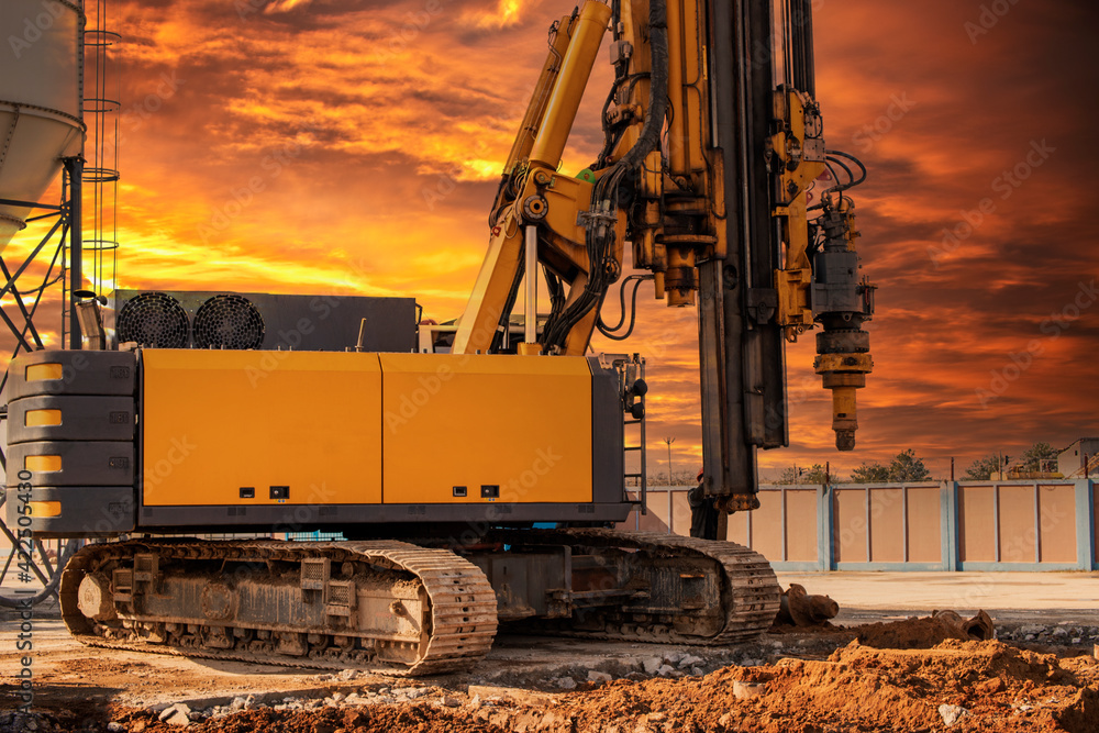 Hydraulic drilling rig against the backdrop of the sunset sky ...