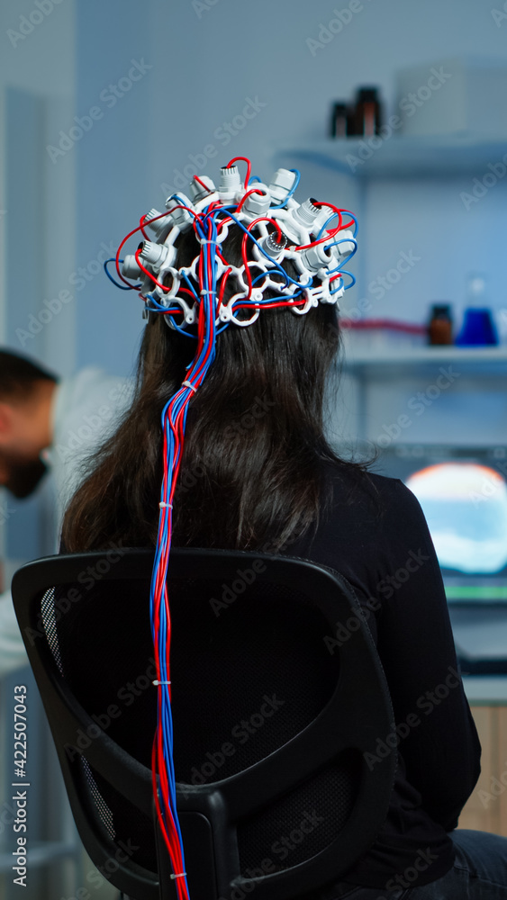 Back view of woman patient wearing performant eeg headset sitting on ...
