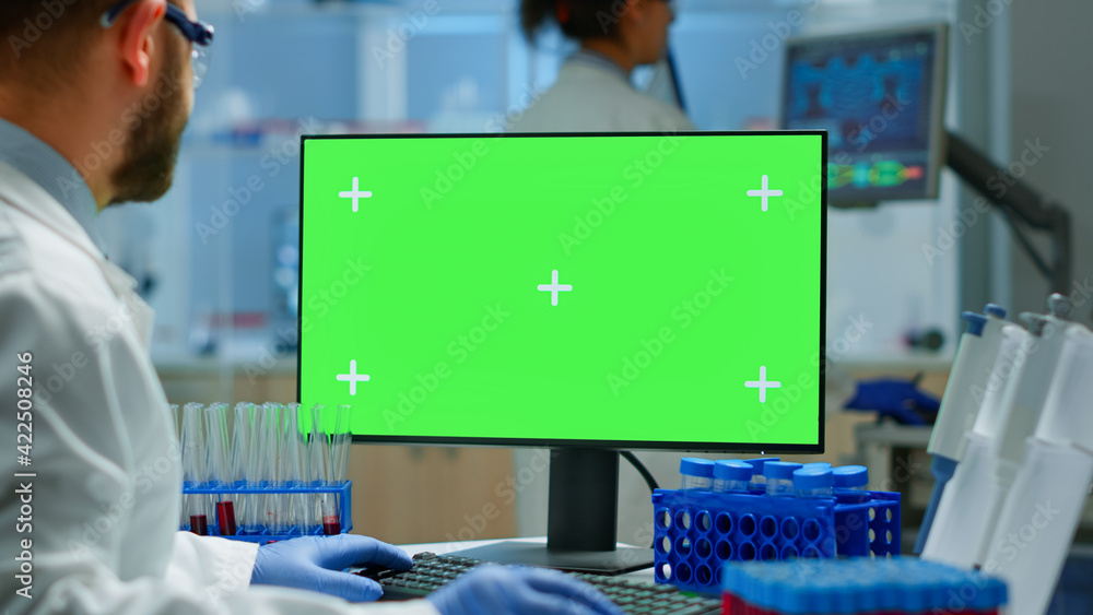 Fotka „Man doctor working at pc with green screen in modern equipped ...