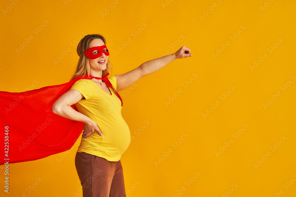 attractive smiling pregnant woman in superhero costume, wearing red ...