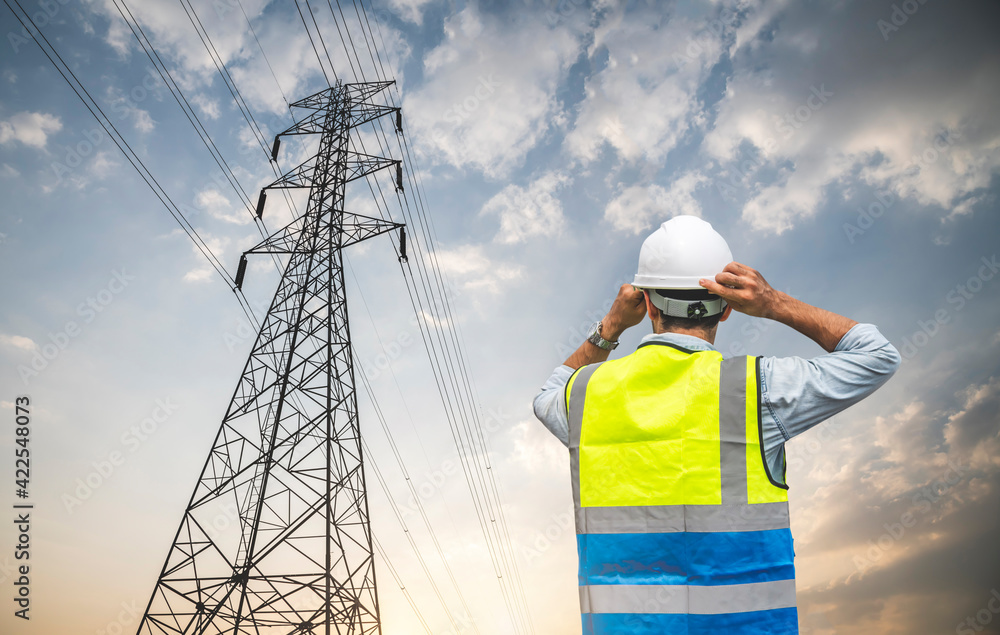 Electrical engineer standing and looking with high voltage electricity ...