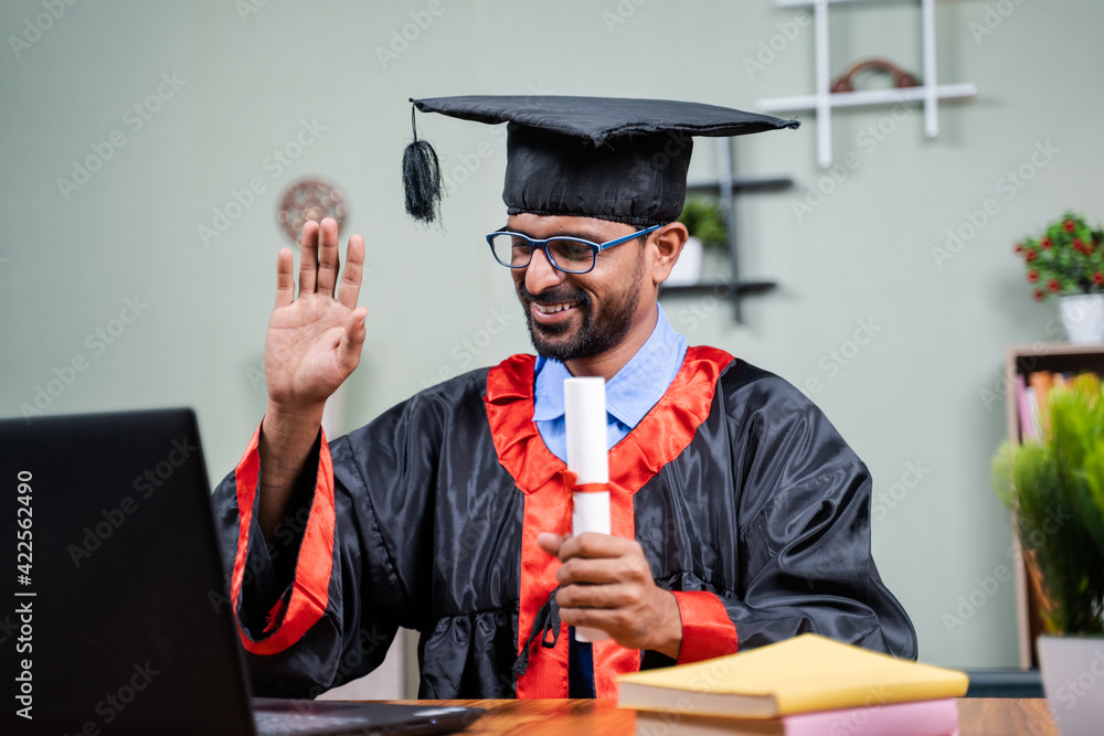 Student attending virtual graduation from laptop by holding certificate ...