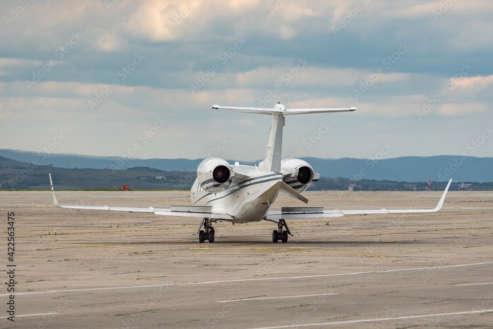 Side back view of white business airplane with jet engines. Attractive ...