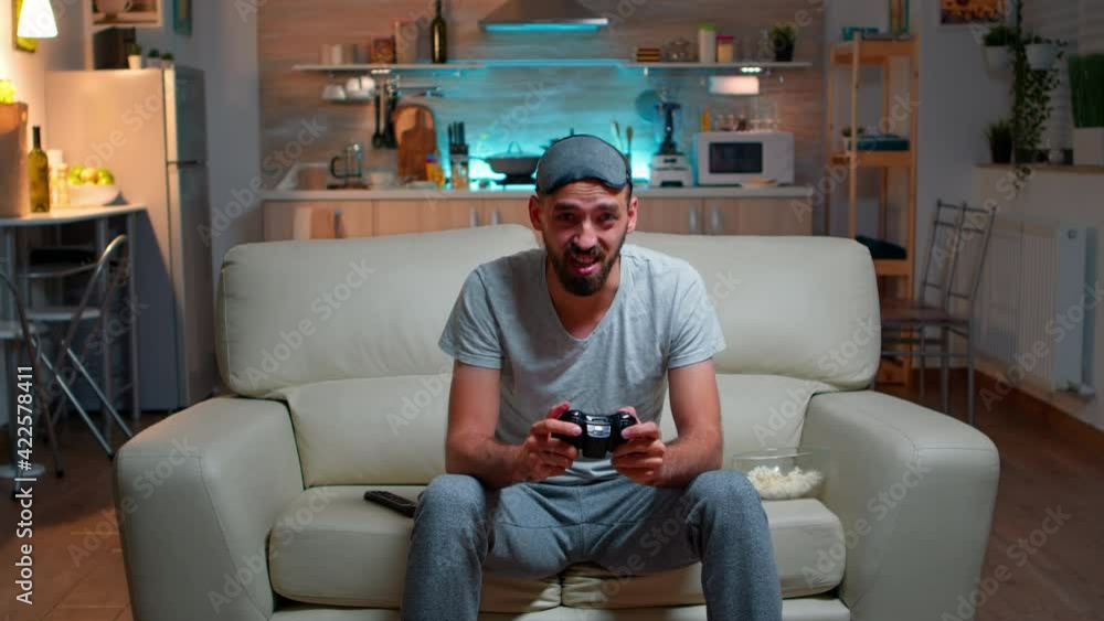 Upset pro gamer sitting in front of television losing soccer video ...