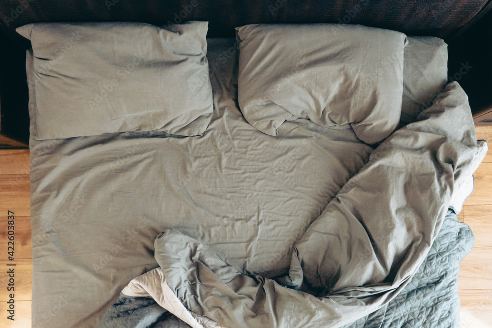 top view of messy bed with gray sheets Stock Photo | Adobe Stock