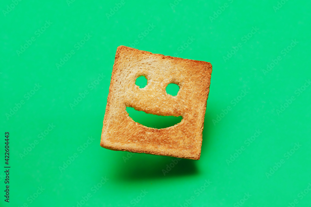 Funny smiling bread toast on a green background. Good mood, positive ...