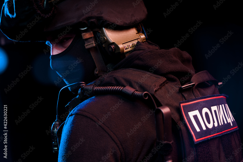 Male in black uniform conforms to Police SWAT. Patch on the back with ...