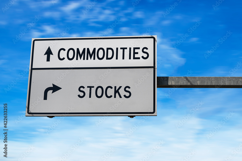 Road sign with words commodities and stocks. White two street signs ...