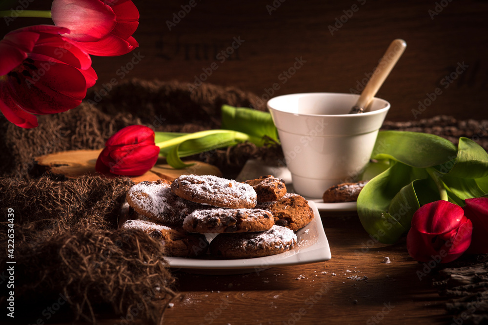 Stillleben. Tee und Kekse, still: Rustikal. Auf dem Tisch liegen rote ...