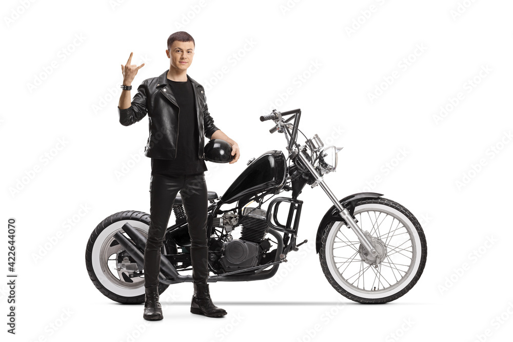 Full length portrait of a biker gesturing rock and roll sign and posing ...