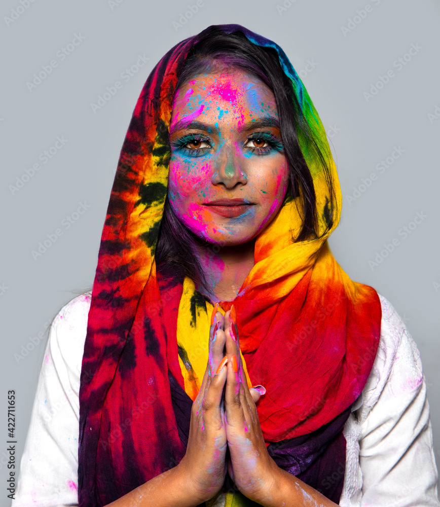 Beautiful Asian young Indian woman in namaste gesture celebrating Holi ...