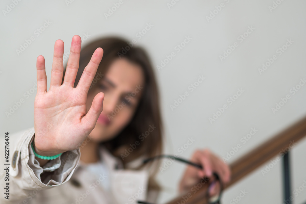 Young woman putting the palm of her hand forward communicating ...