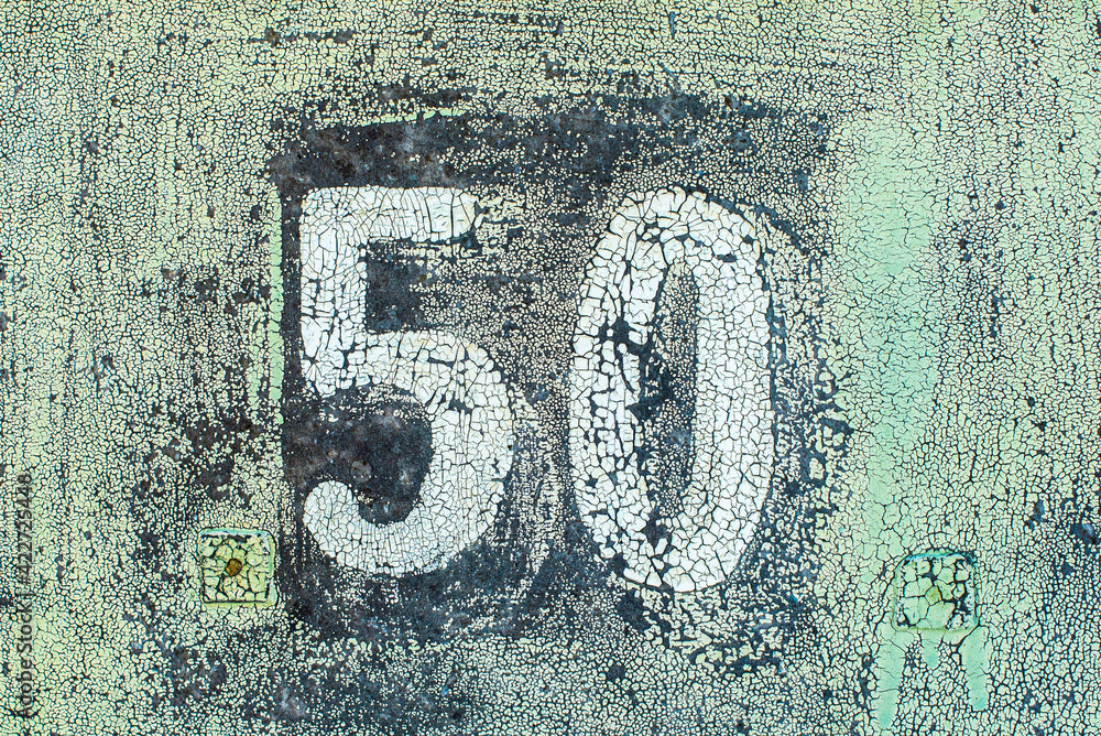 house number 50. celadon green old shabby wall. cracks and peeling ...