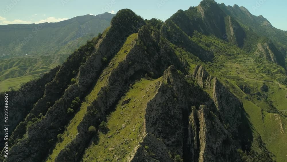 Aerial forward above epic rocky peaks of great triangle mountains ...