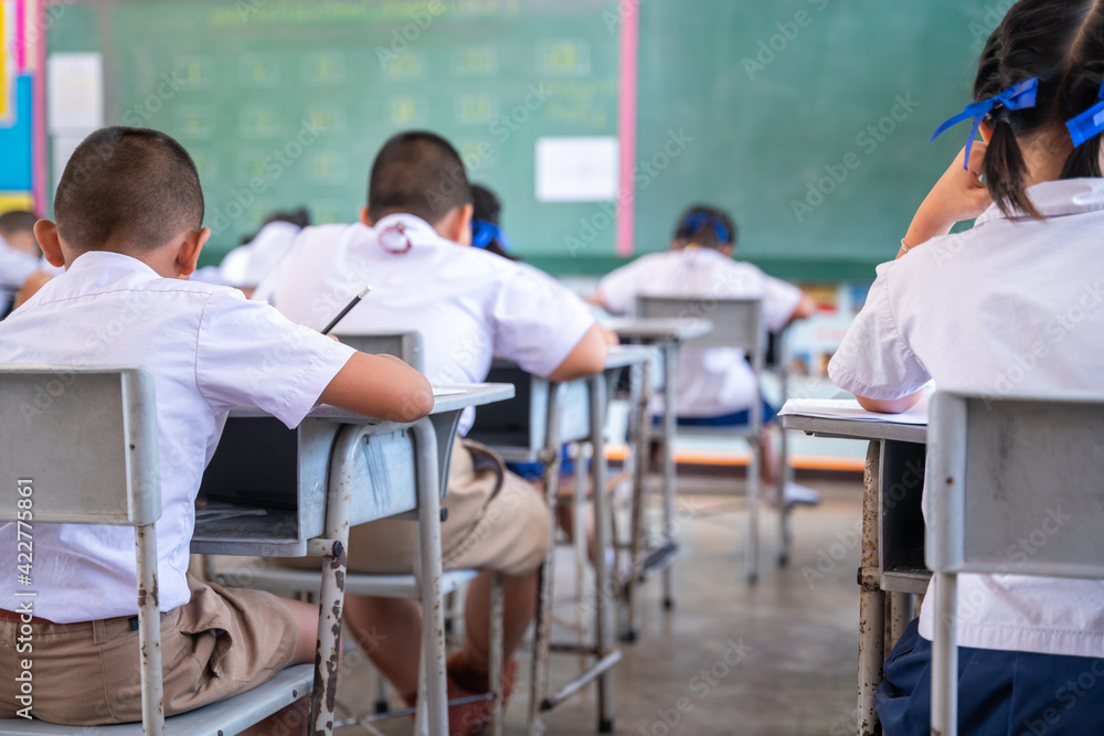 Close up of Writing test in exam with behind child asian students group ...